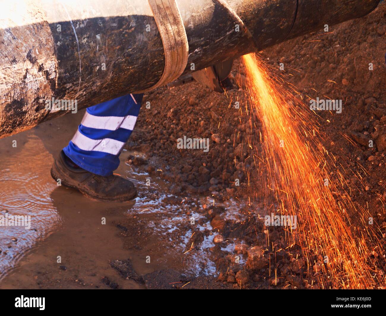 Man works, big pipe cutting with electric spiral machine. Hor sparks ...