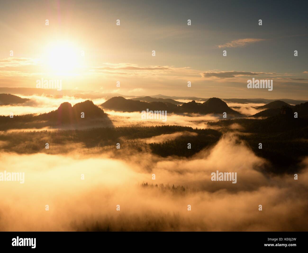 Spring colorful mist between summits. The sandstone cliff above forest ...