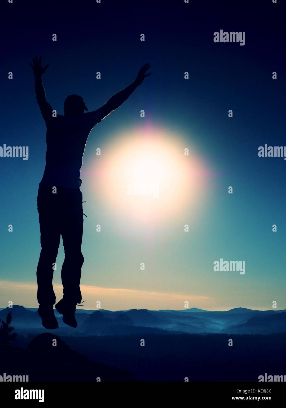 Jumping man. Young crazy man is jumping on colorful sky background ...