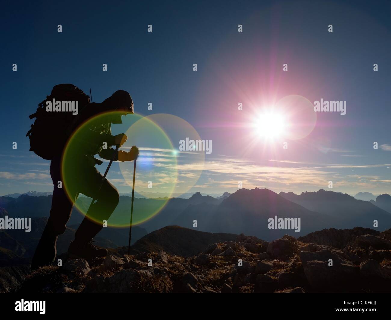 Lens flare light, strong defect. Tourist guide on trekking path with ...