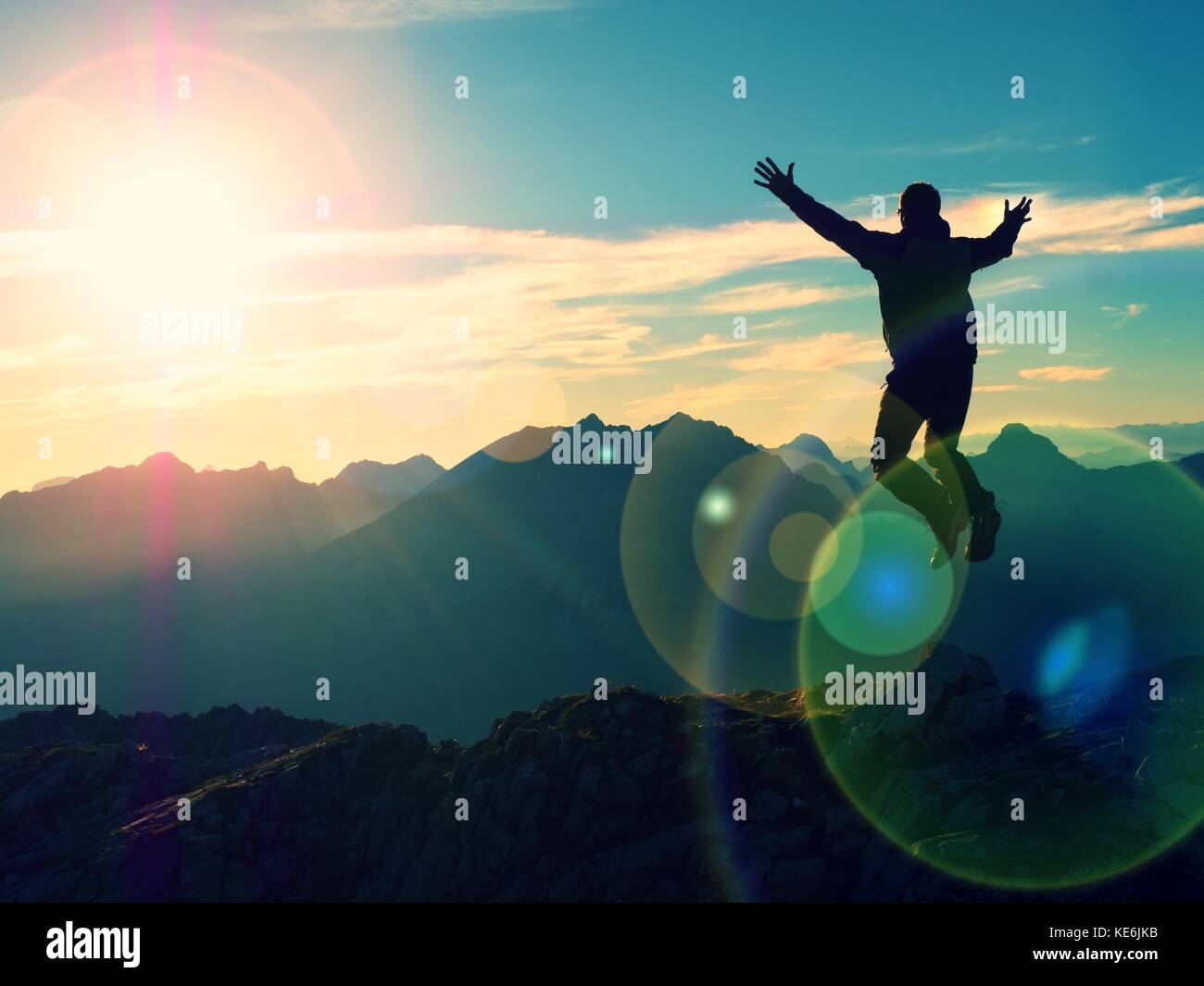 Lens flare effect. Bow light circles. Crazy hiker jumping at peak of ...