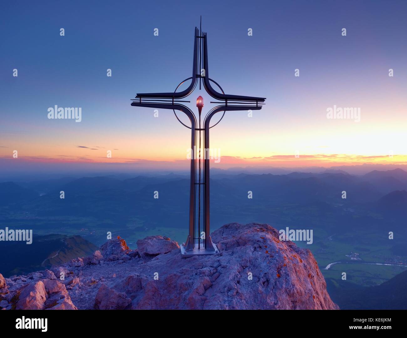 Steel crucifix at mountain peak in Alps. Sharp rocky summit, daybreak ...