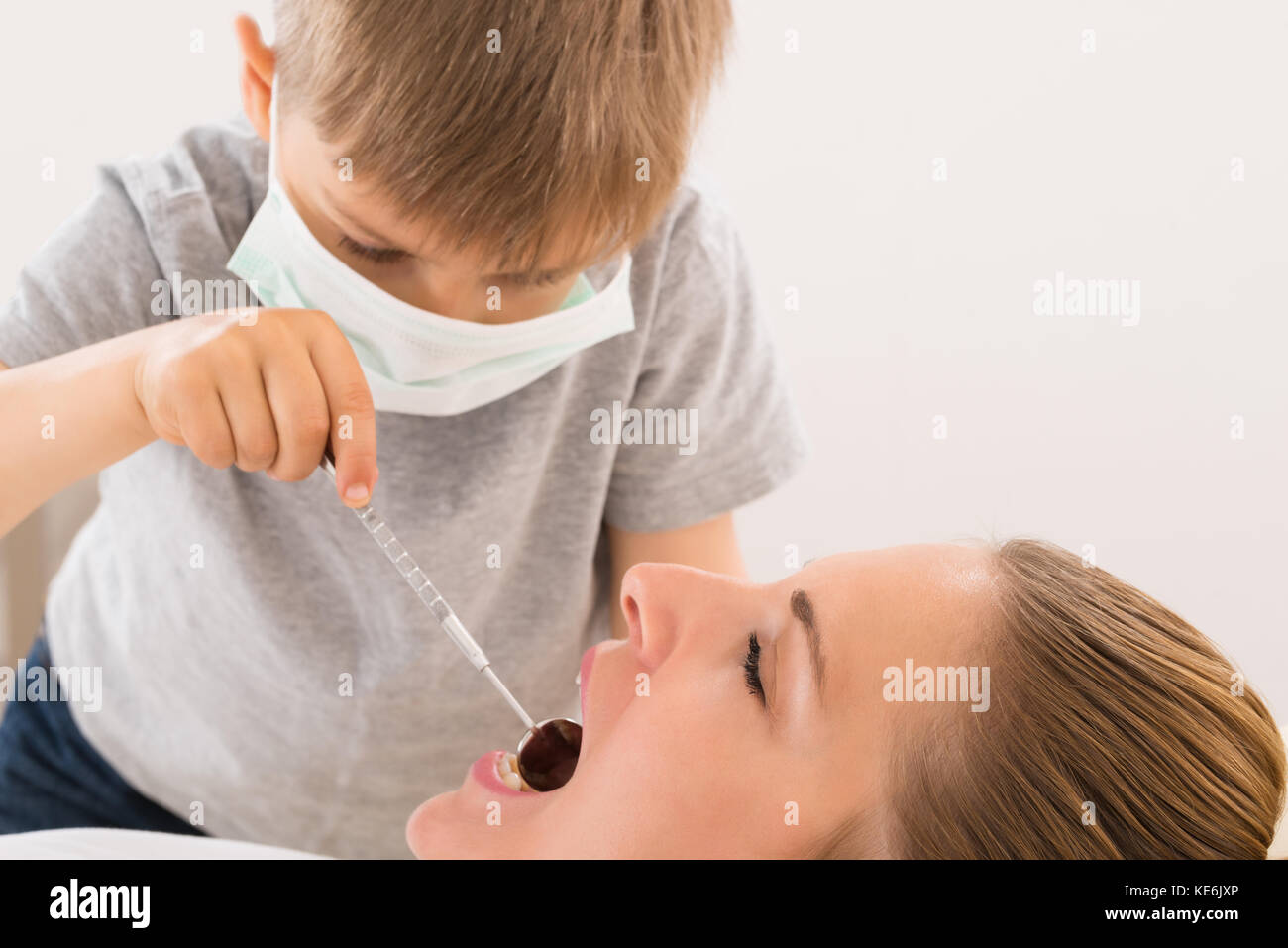 Close-up Of Little Boy Examining Teeth Of Young Woman Stock Photo - Alamy