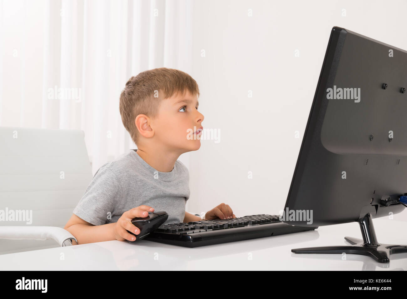 Photo Of Little Boy Using Computer At Home Stock Photo - Alamy