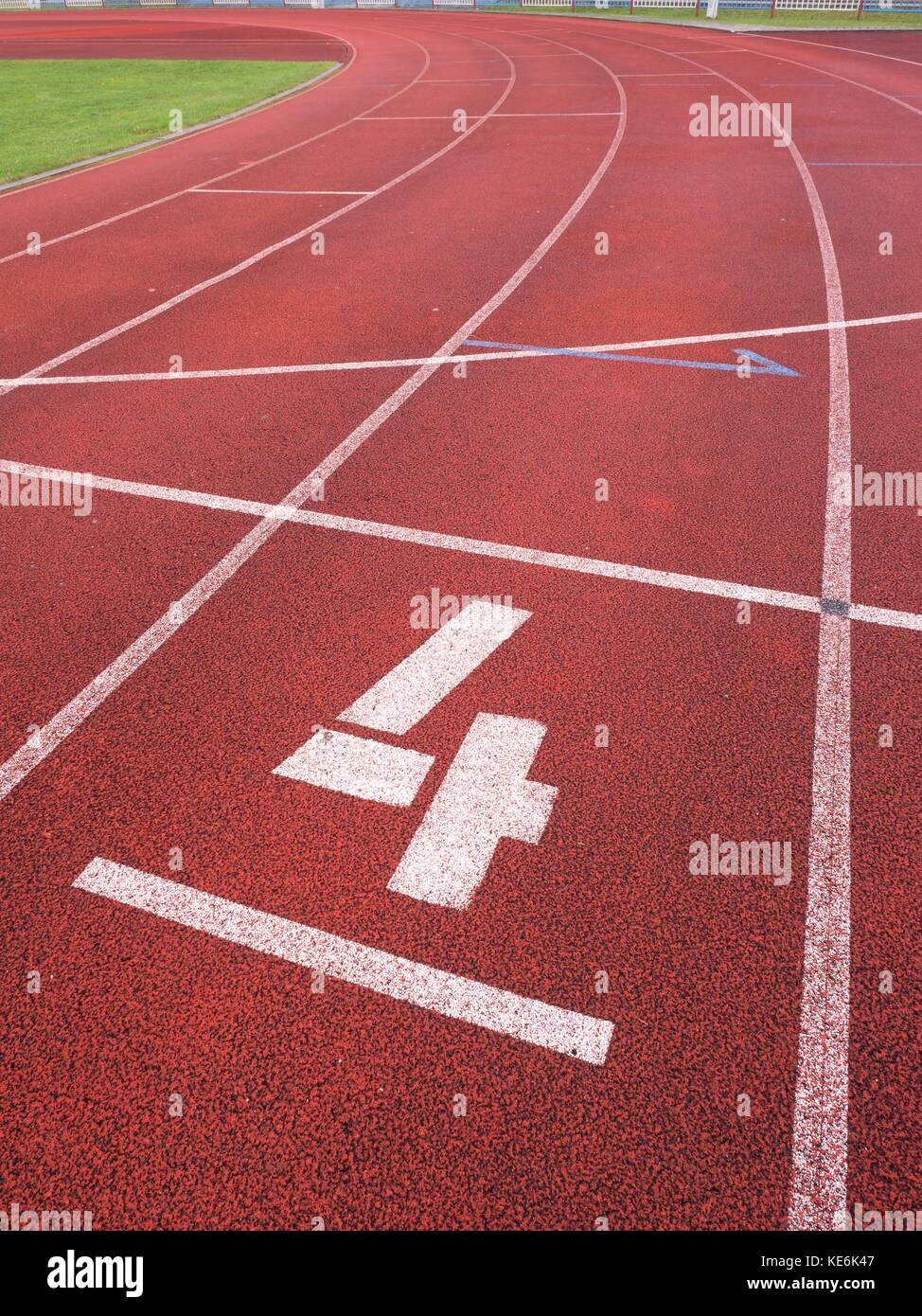 Number four. White track number on red rubber racetrack, texture of ...