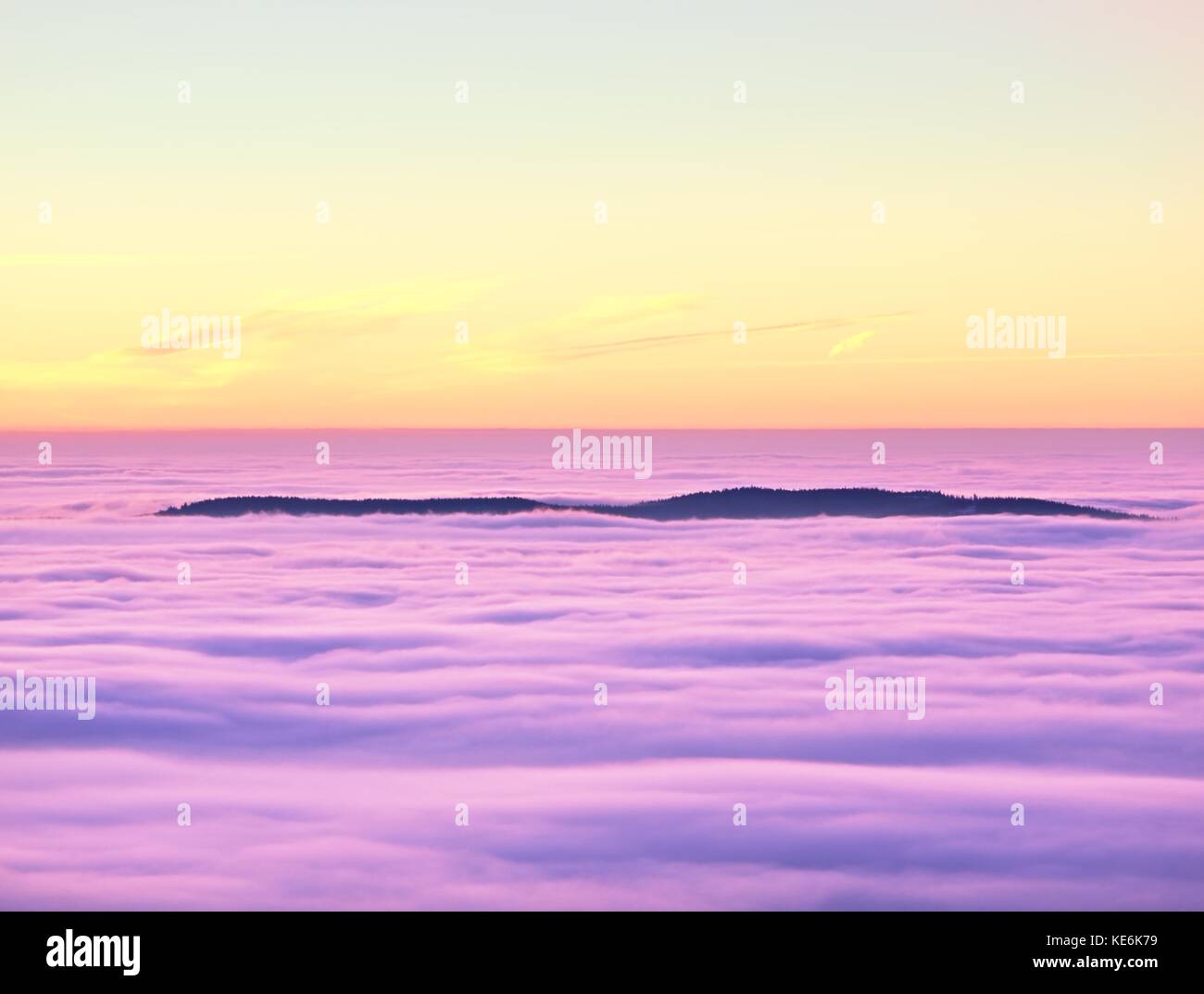 Misty valley in winter mountains. Peaks of mountains above creamy mist ...