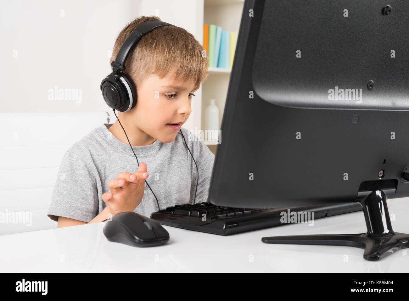 Boy Listening Music In Headphone While Using Computer Stock Photo - Alamy
