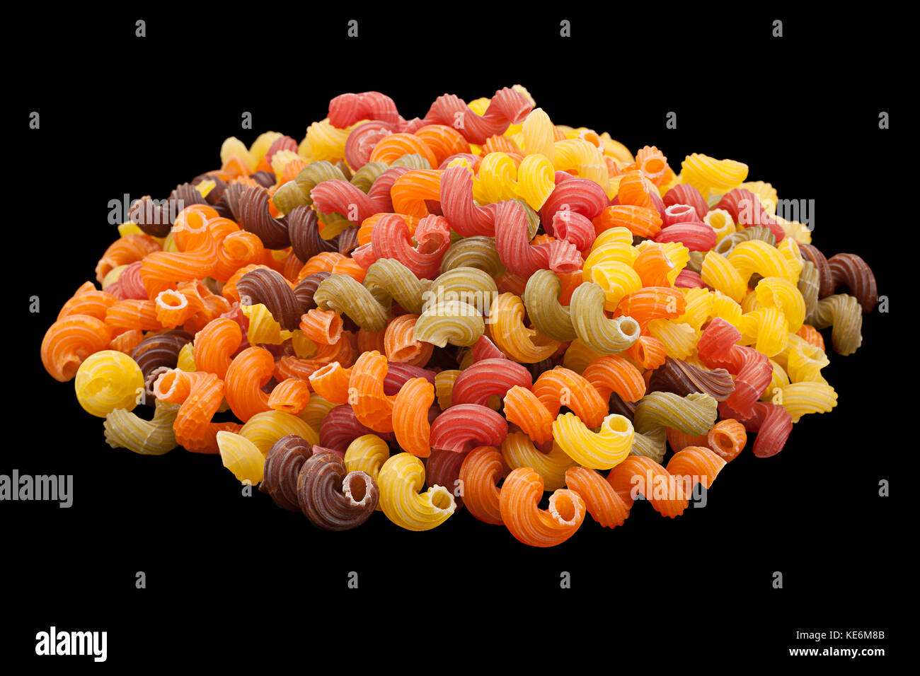Multicolor dry swirl pasta isolated on black background Stock Photo - Alamy