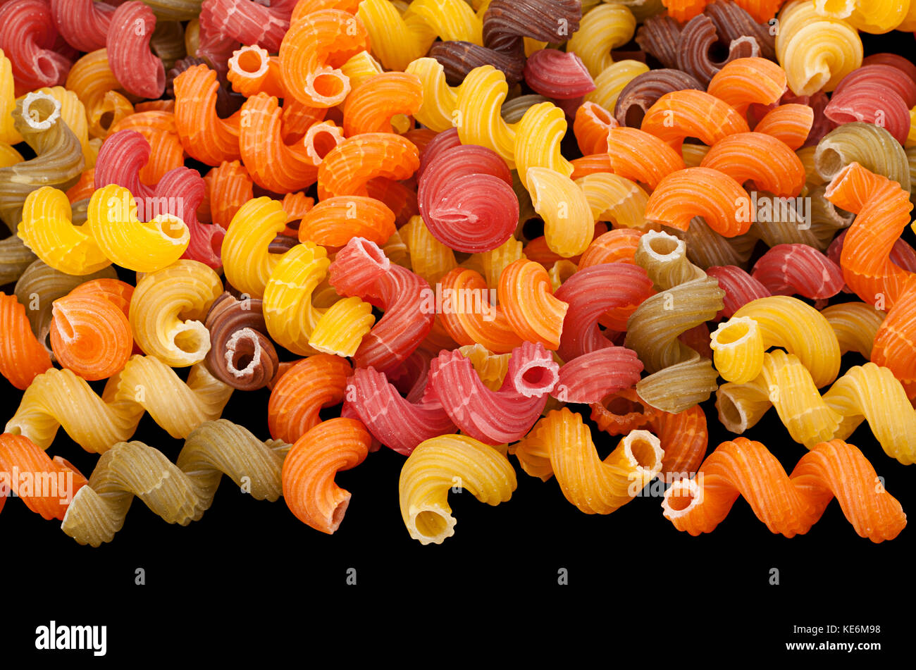 Multicolor dry swirl pasta closeup view background Stock Photo - Alamy