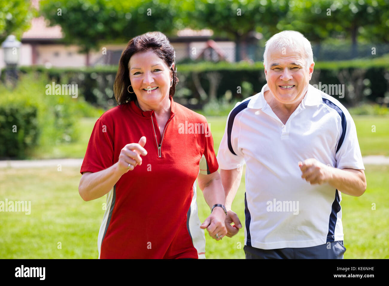 Smiling Senior Couple Running Together In Park Stock Photo - Alamy