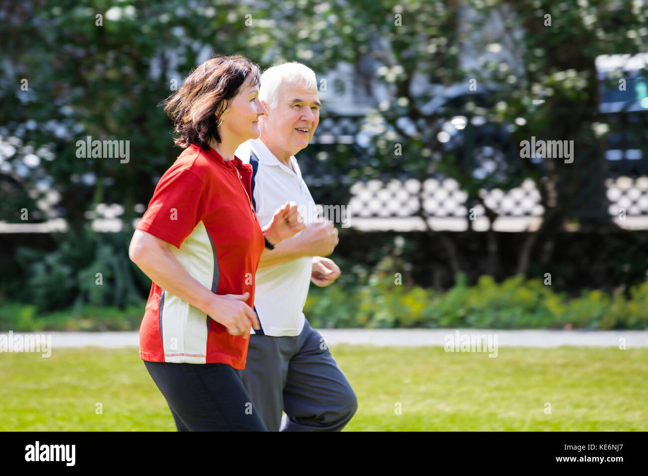 Smiling Senior Couple Running Together In Park Stock Photo - Alamy