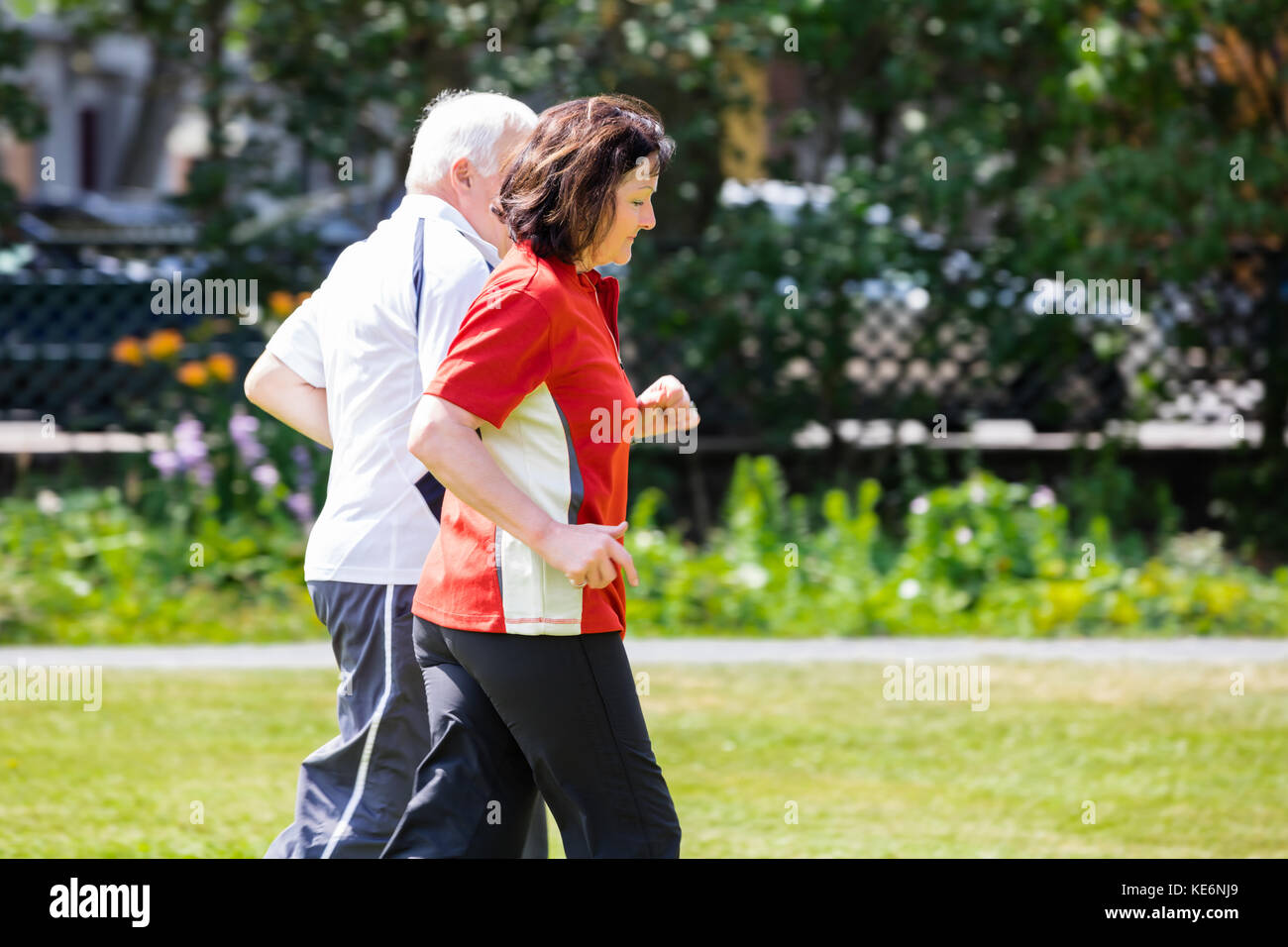 Smiling Senior Couple Running Together In Park Stock Photo - Alamy