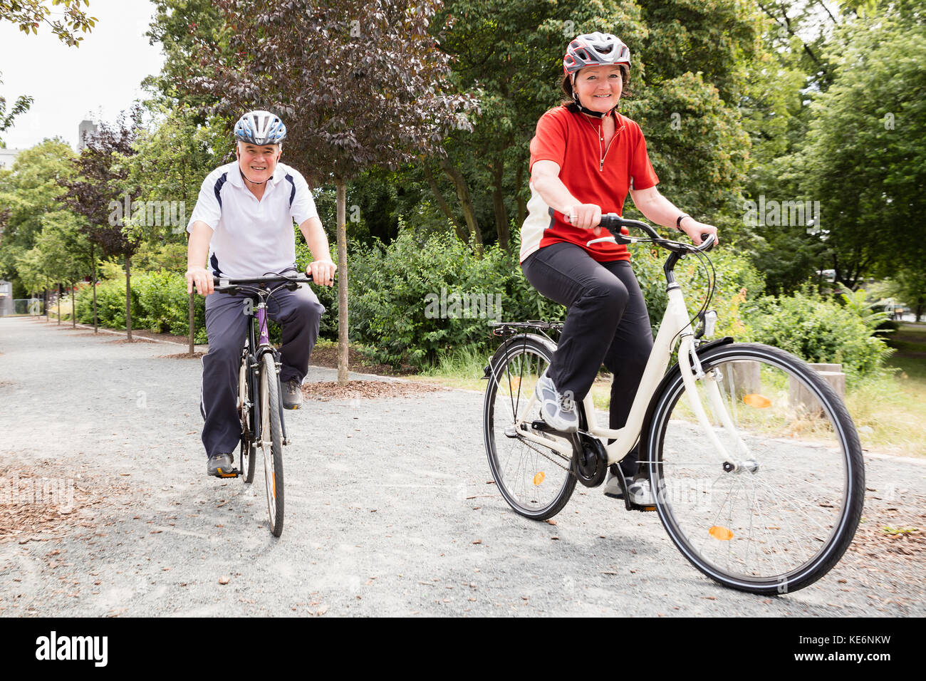 Smiling Elderly Senior Couple Cycling In Park At Morning Stock Photo ...