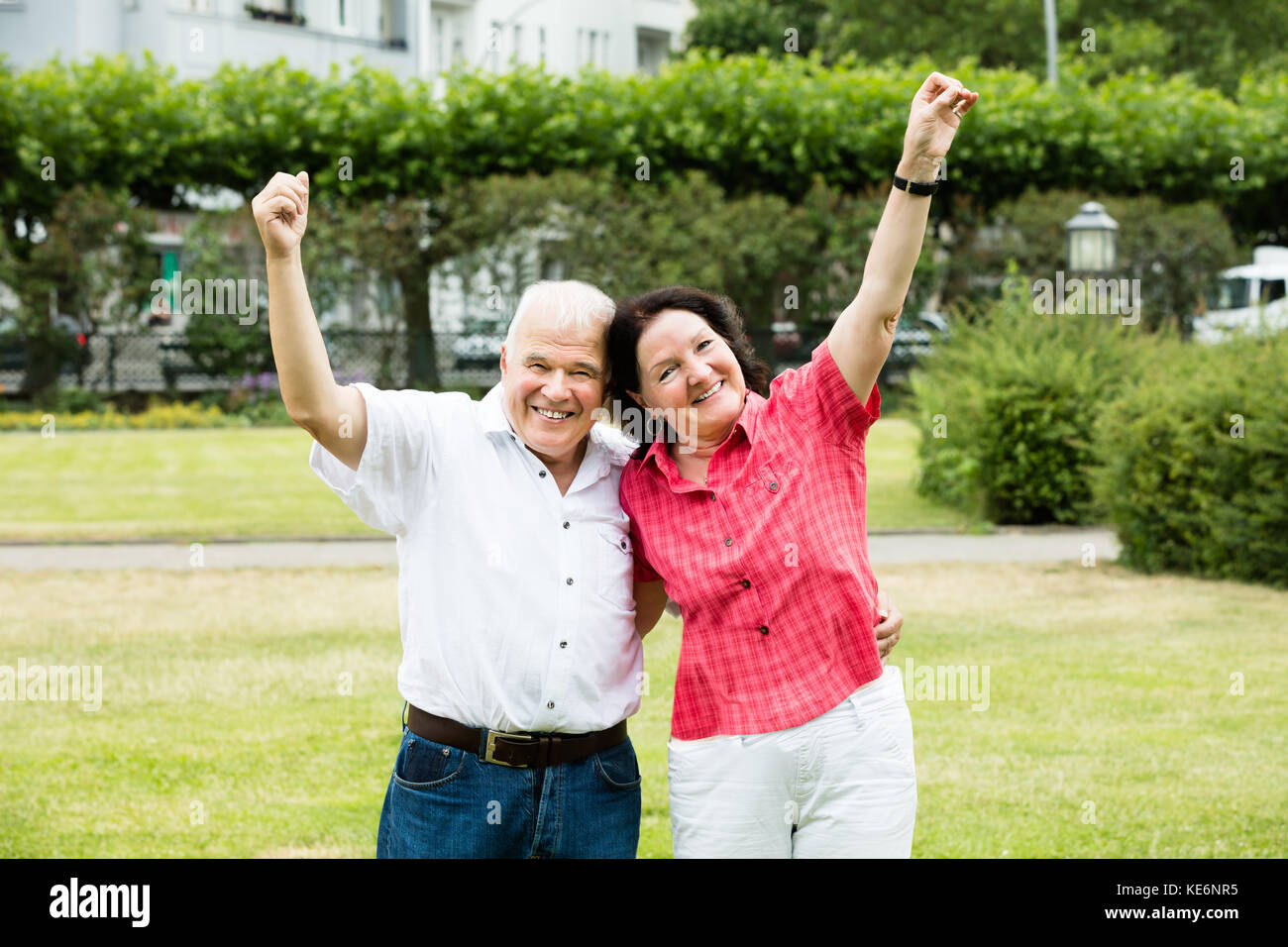 Portrait Of Elder Senior Couple Raising Their Arms In Park Stock Photo ...