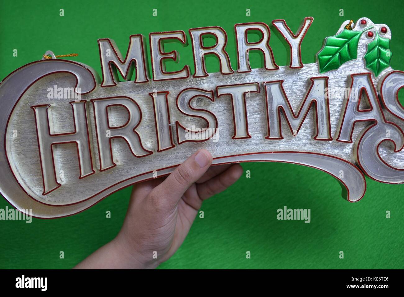 Merry Christmas in hand on green background Stock Photo - Alamy