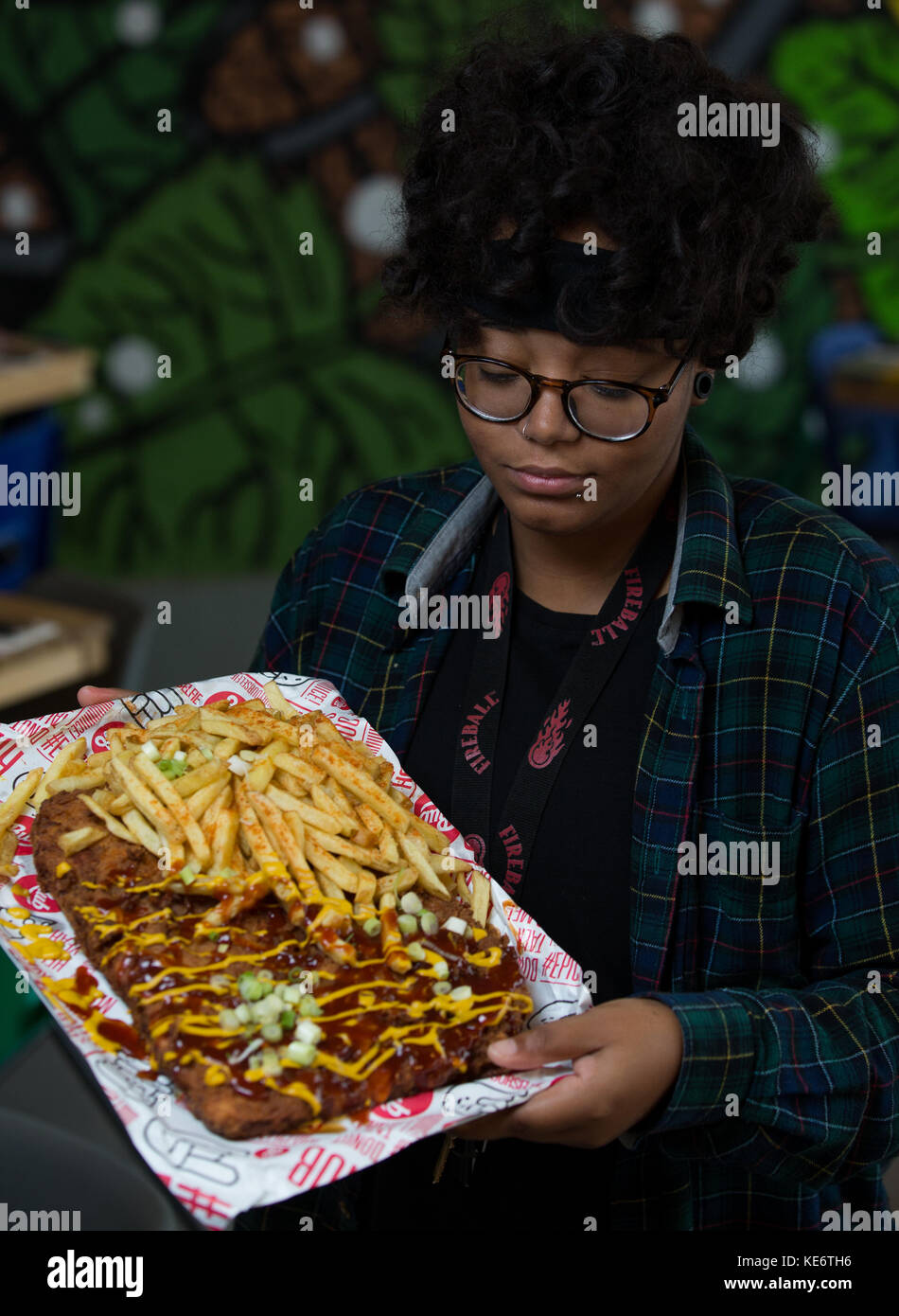 Jojo Fernanandes holds up their giant chicken nugget dish which is part ...