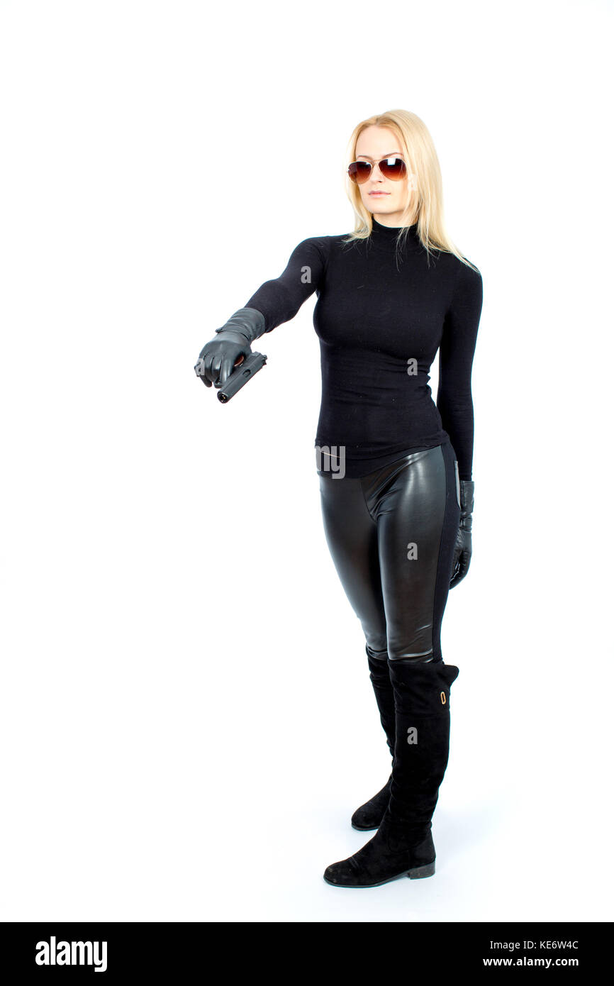 Young blonde woman in a black suit with a gun Stock Photo - Alamy