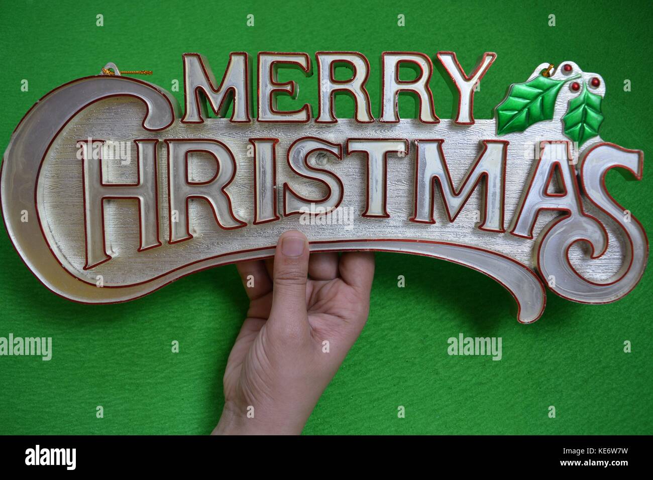 Merry Christmas in hand on green background Stock Photo - Alamy