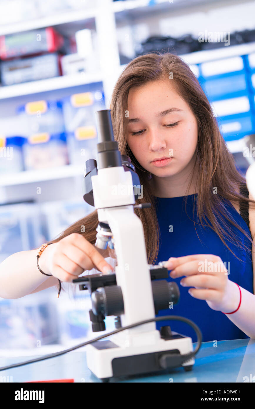 A teenage girl in a school laboratory in chemistry and biology classes ...