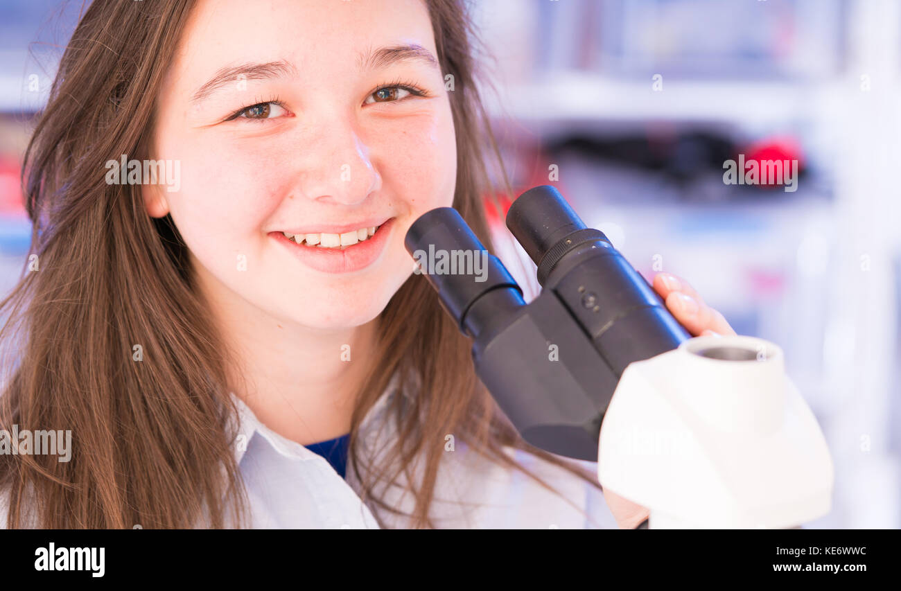 A teenage girl in a school laboratory in chemistry and biology classes ...