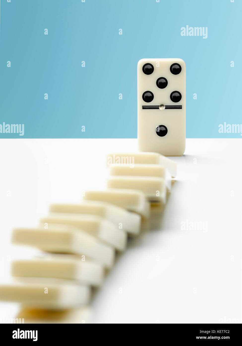 Domino toppling row of dominos Stock Photo - Alamy