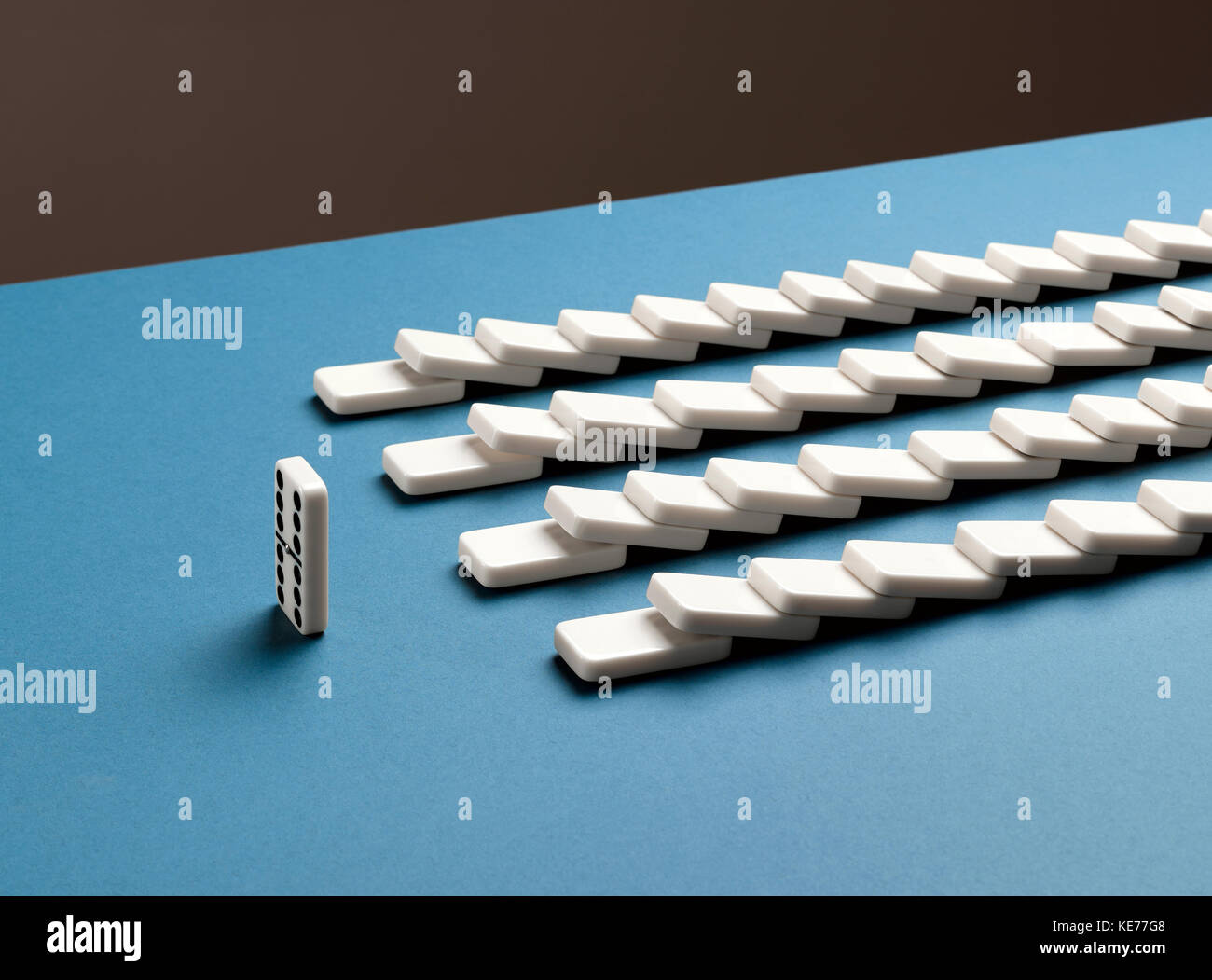 One standing domino and toppled dominoes in rows Stock Photo - Alamy