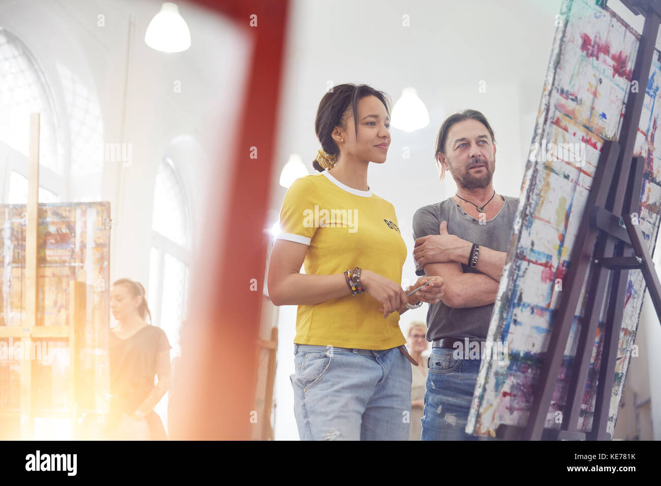 Artists looking at painting in art class studio Stock Photo - Alamy