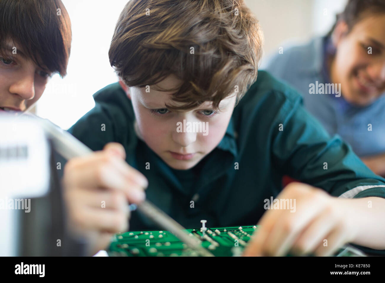 Focused boy student assembling electronics in classroom Stock Photo - Alamy