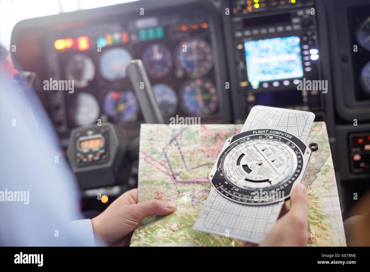Pilot checking navigational map and compass instrument in airplane ...