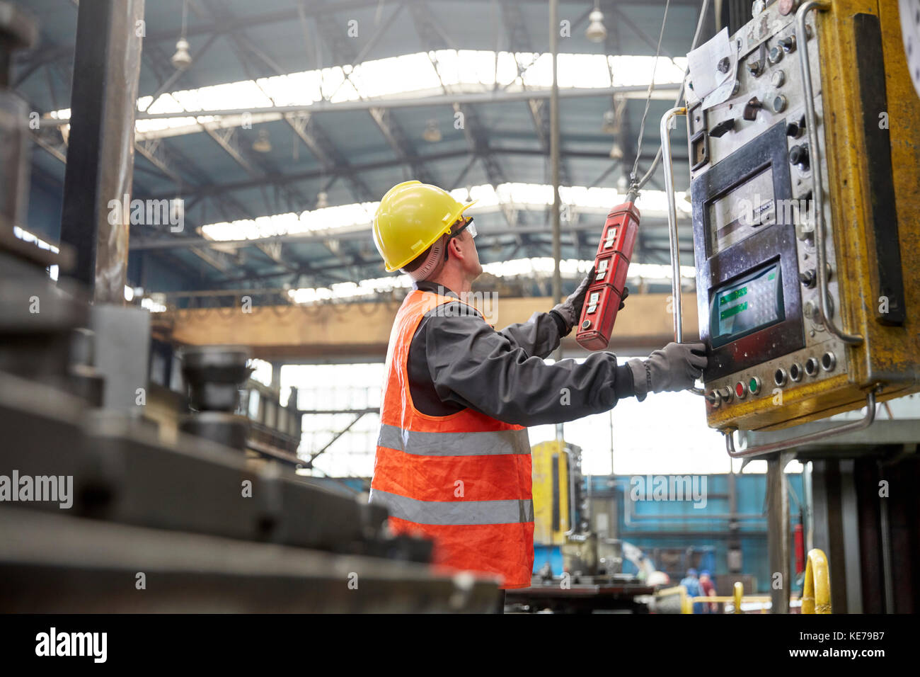 Male worker operating machinery at control panel in factory Stock Photo ...