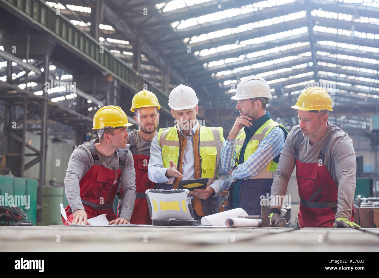 Male foreman, engineers and workers meeting in factory Stock Photo - Alamy
