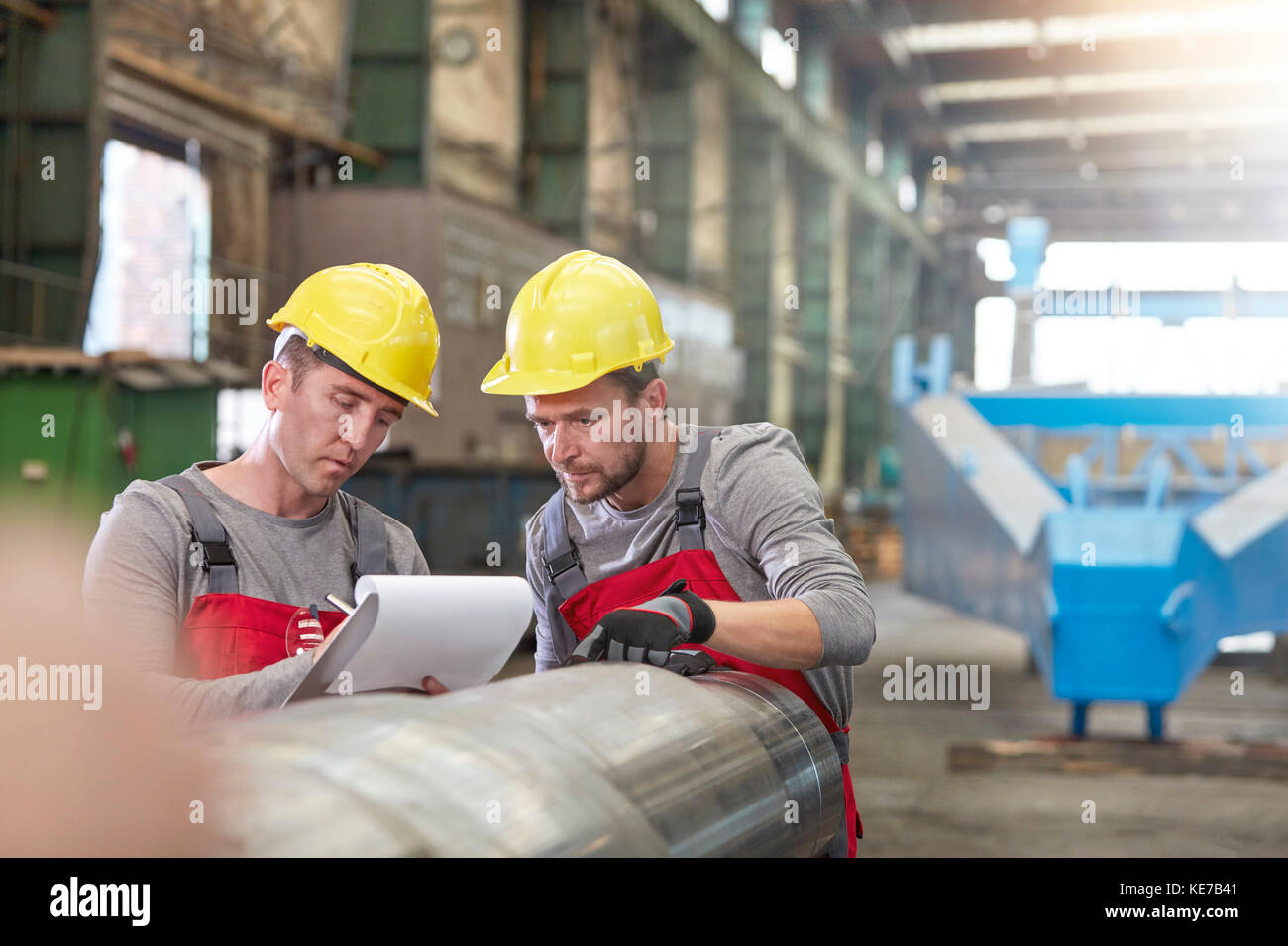 Male workers with clipboard in factory Stock Photo - Alamy