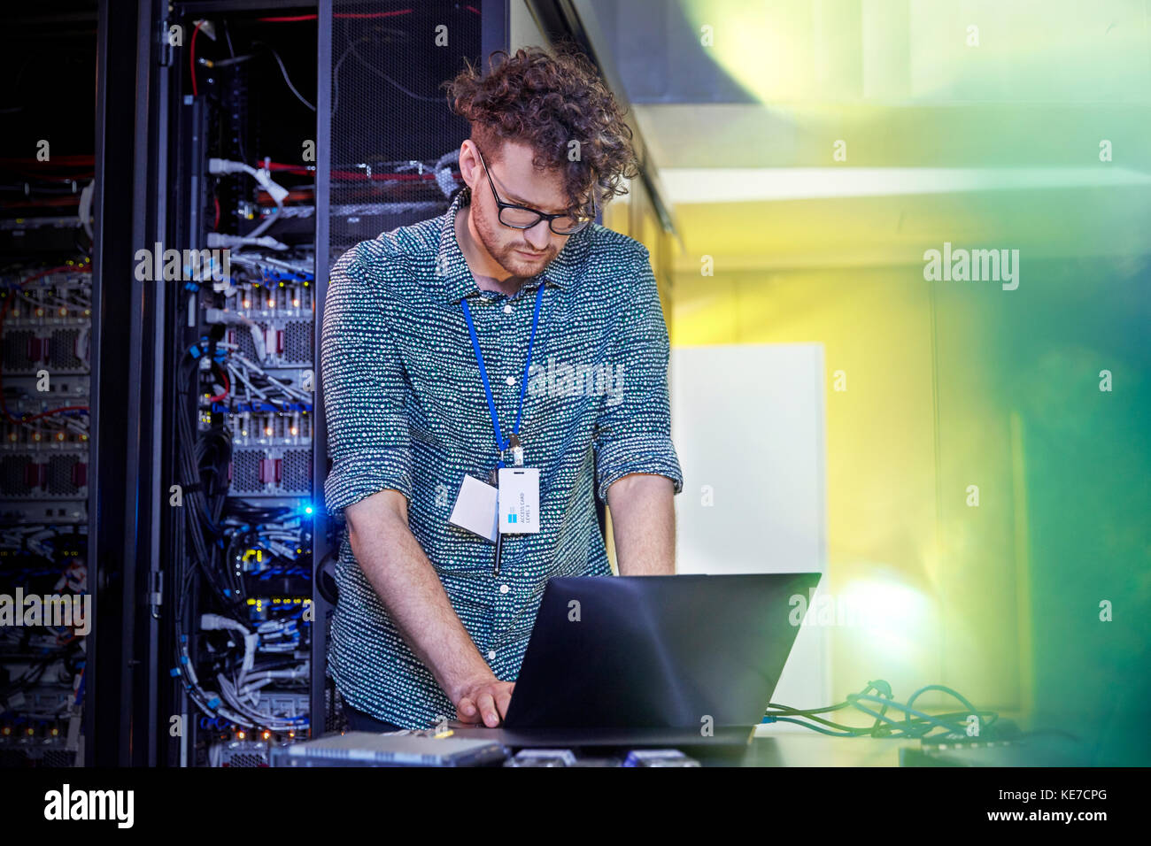 Male IT technician working at laptop in server room Stock Photo - Alamy