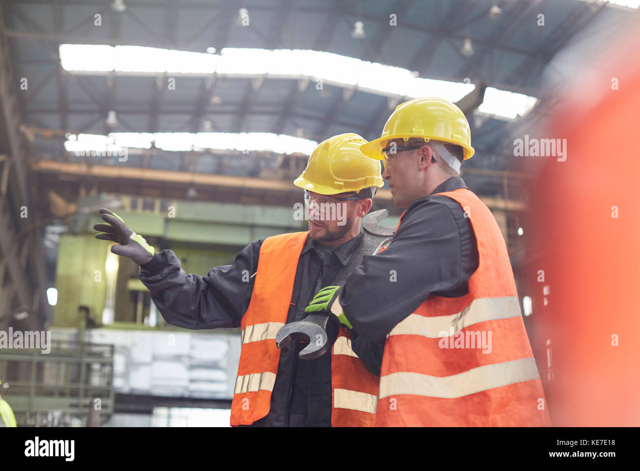 Male workers talking in factory Stock Photo - Alamy