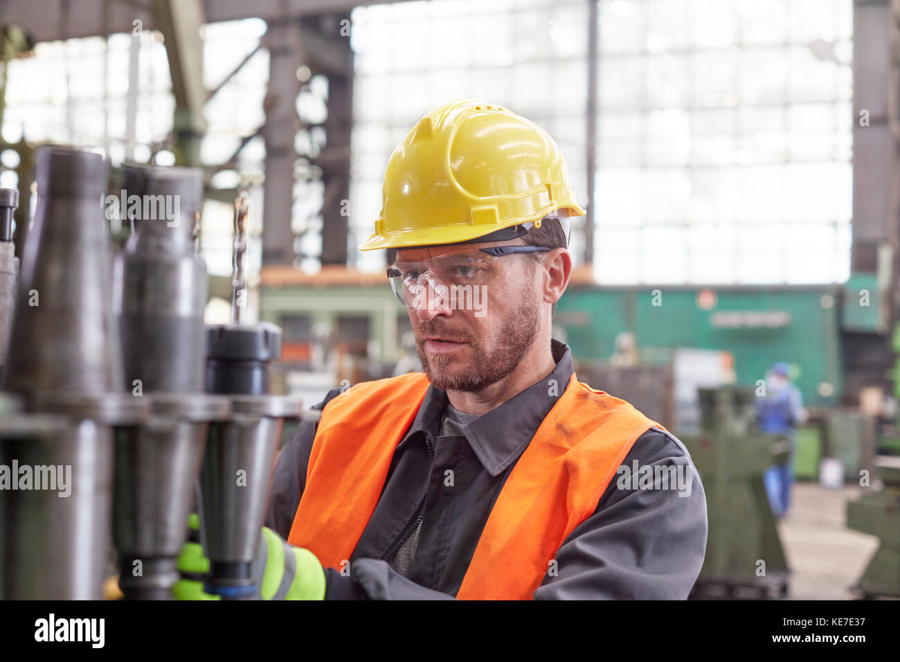 Focused male worker examining steel parts in factory Stock Photo - Alamy
