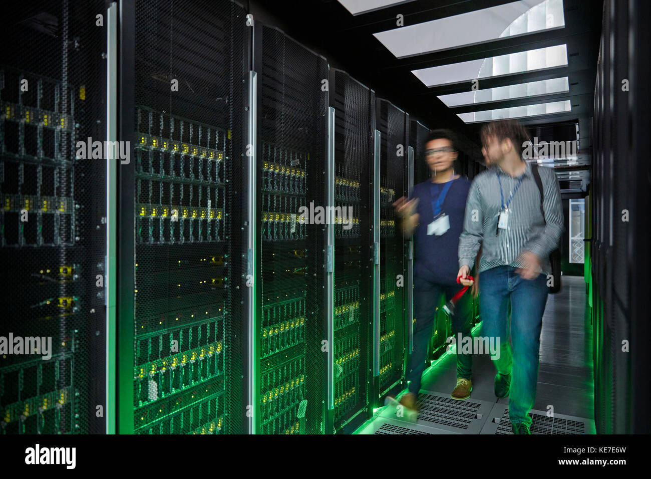 IT technicians walking and talking in dark server room Stock Photo - Alamy
