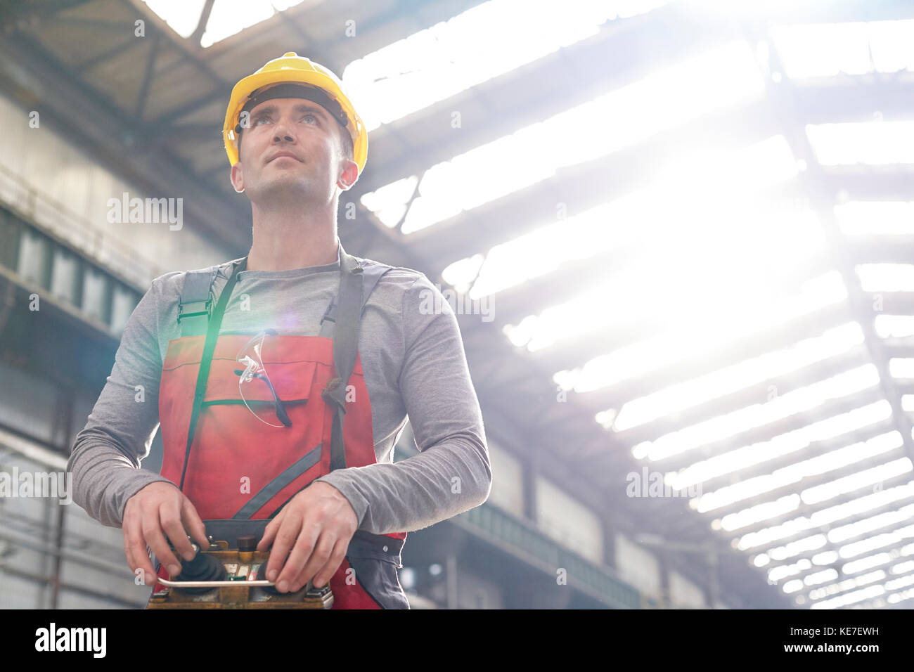 Male worker operating machinery with remote control in factory Stock ...