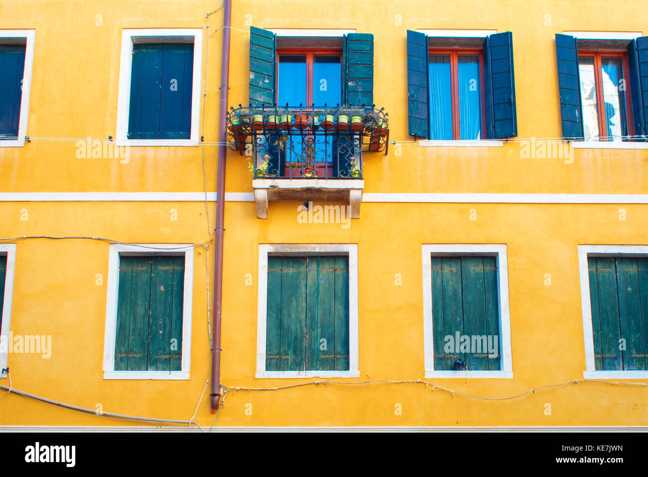 Italian window with wooden shutters bright yellow wall Stock Photo - Alamy