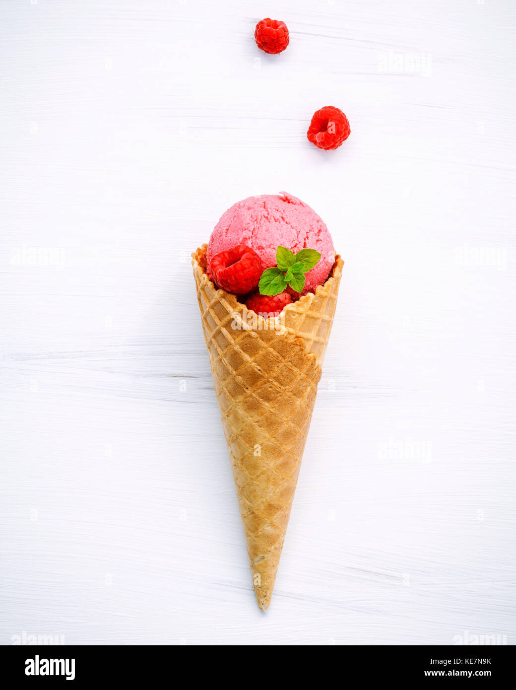 Raspberry ice cream in cone with fresh raspberry and peppermint leaves ...