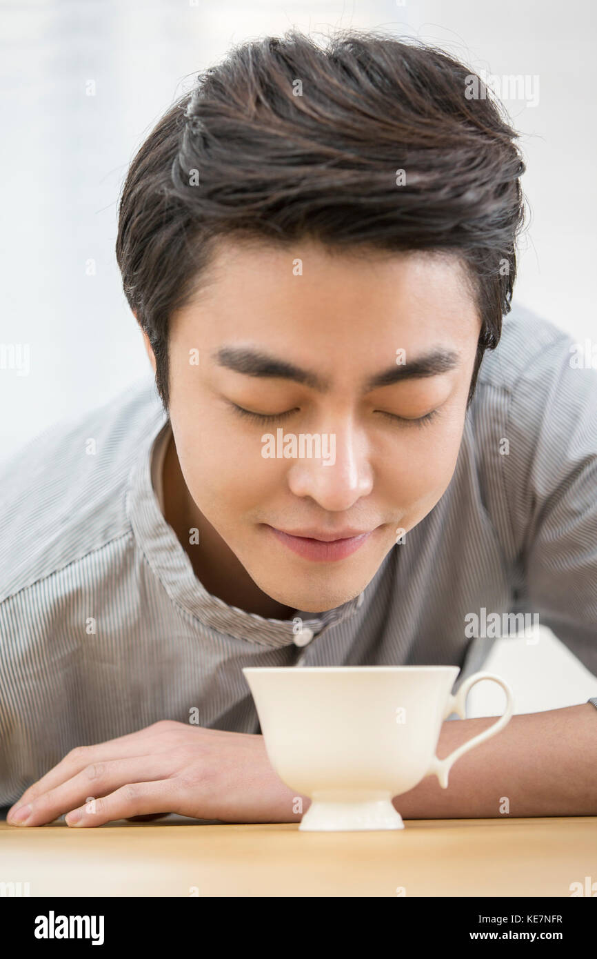Portrait of smiling single man smelling a cup of tea Stock Photo - Alamy