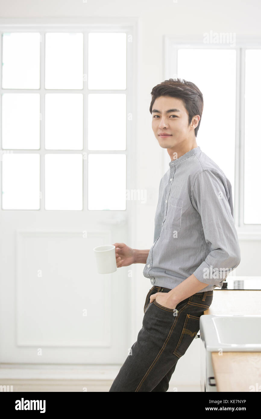 Smiling single man in casual clothes with a mug posing Stock Photo - Alamy