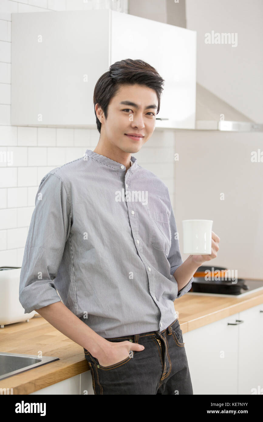 Smiling single man in casual clothes with a mug posing Stock Photo - Alamy