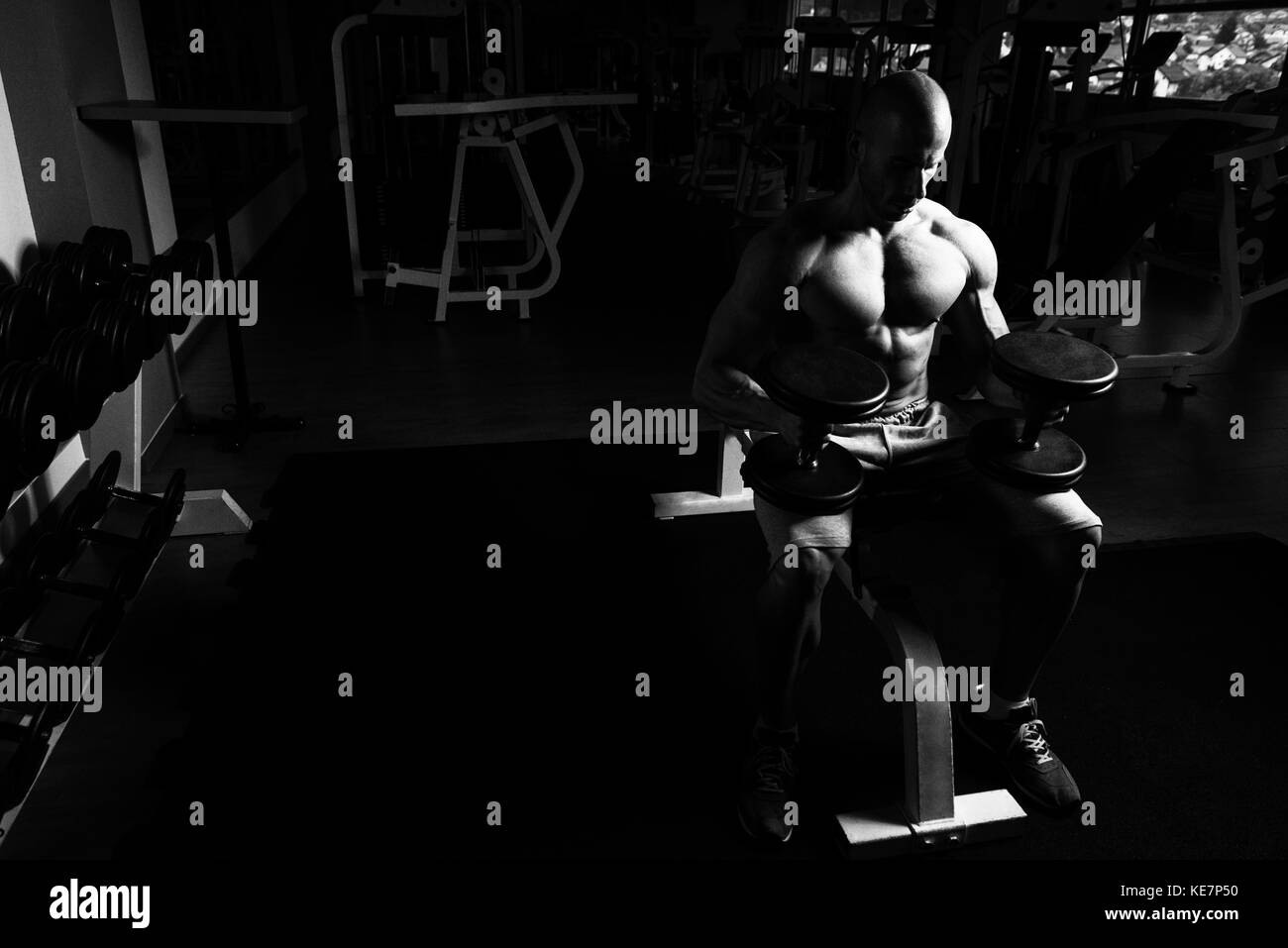 Strong Man In The Gym And Exercising Chest With Dumbbells - Muscular ...