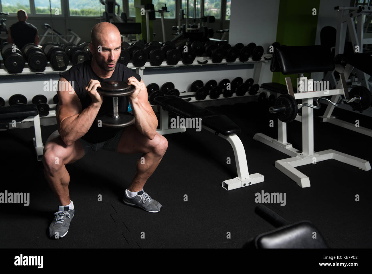 Strong Man In The Gym Exercising Hamstrings With Dumbbells - Muscular ...