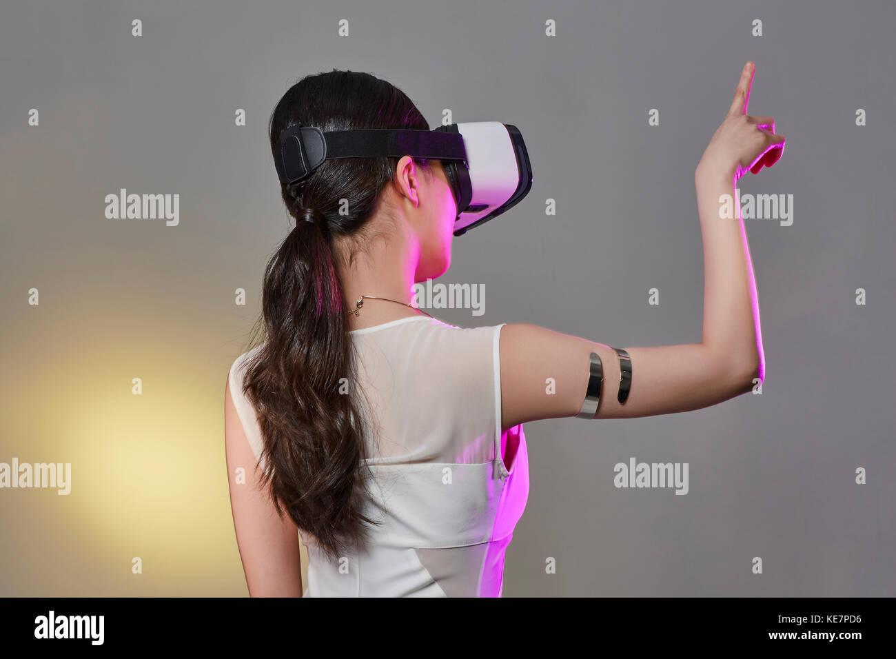 Side view portrait of young woman with virtual reality headset touching ...