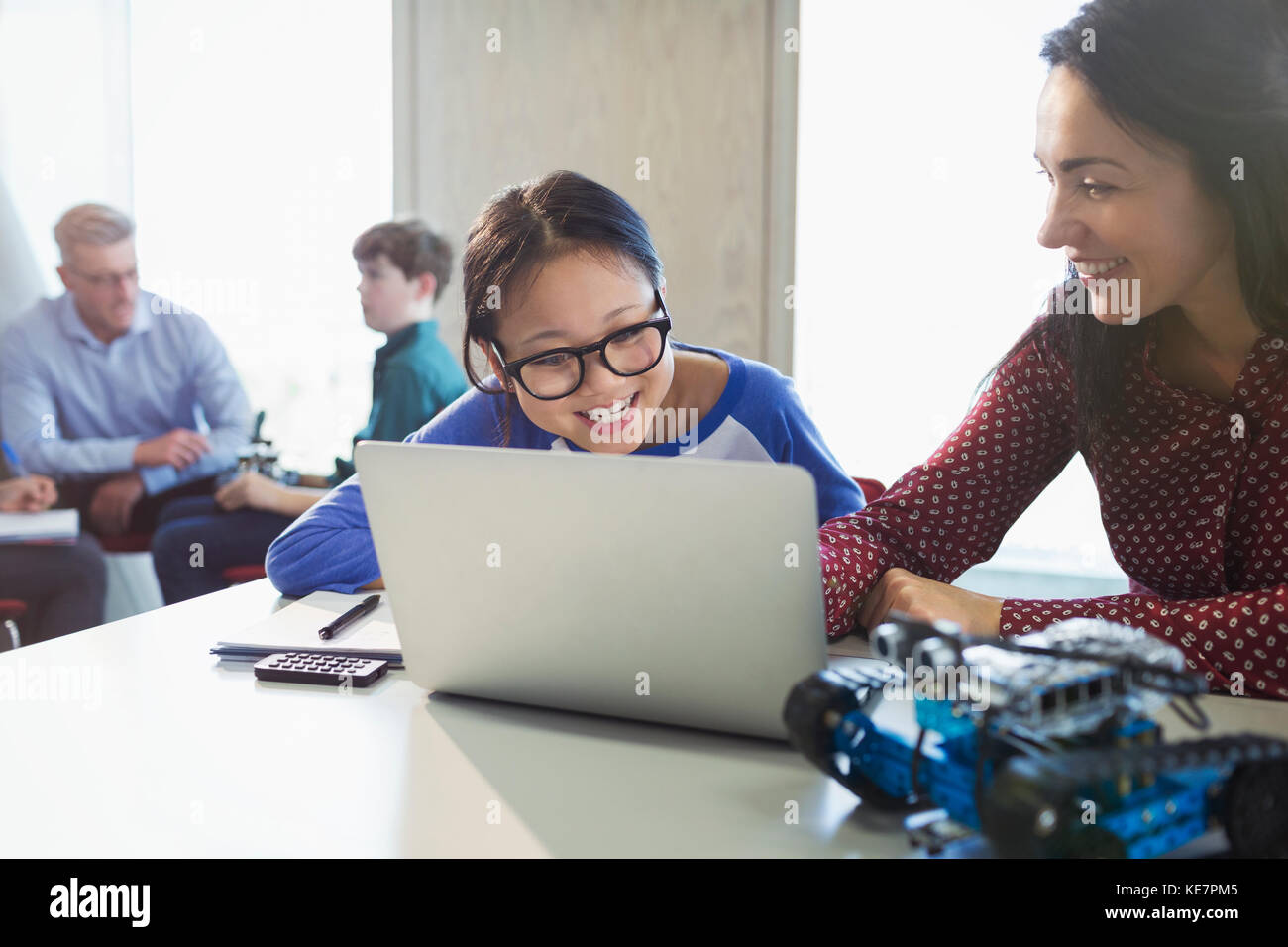 Female teacher and girl student programming robotics at laptop in ...