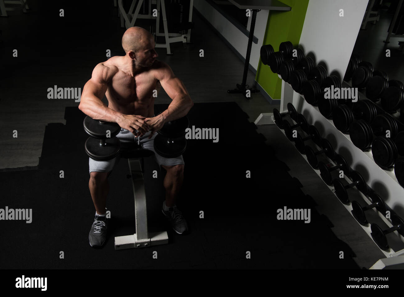 Strong Man In The Gym And Exercising Chest With Dumbbells - Muscular ...