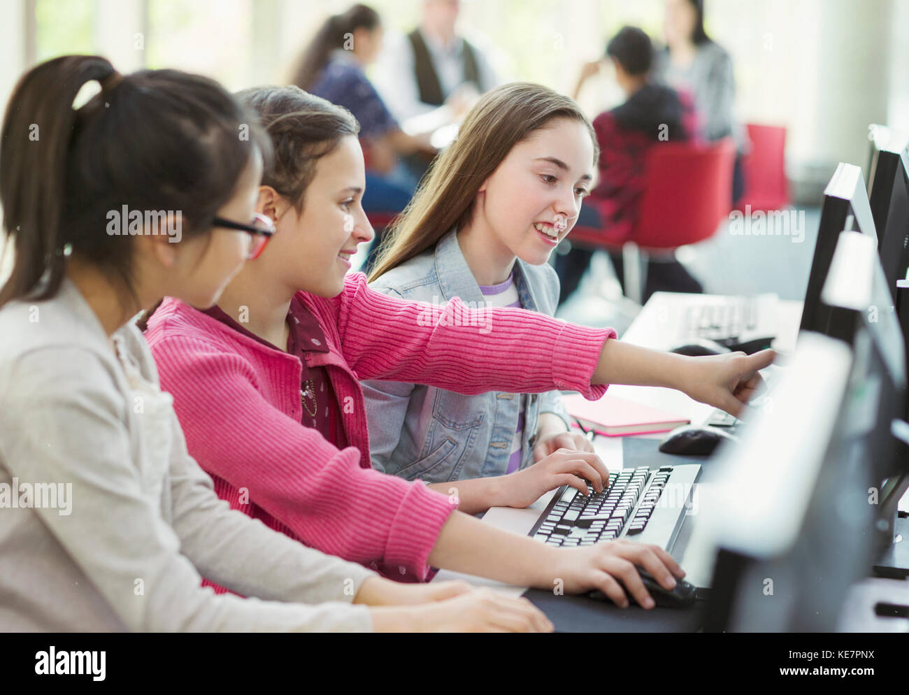 Girl students studying together at computer in library Stock Photo - Alamy