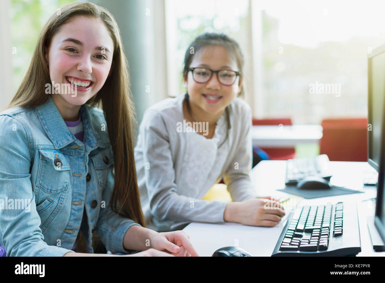 Portrait smiling, confident girl students researching at computer in ...