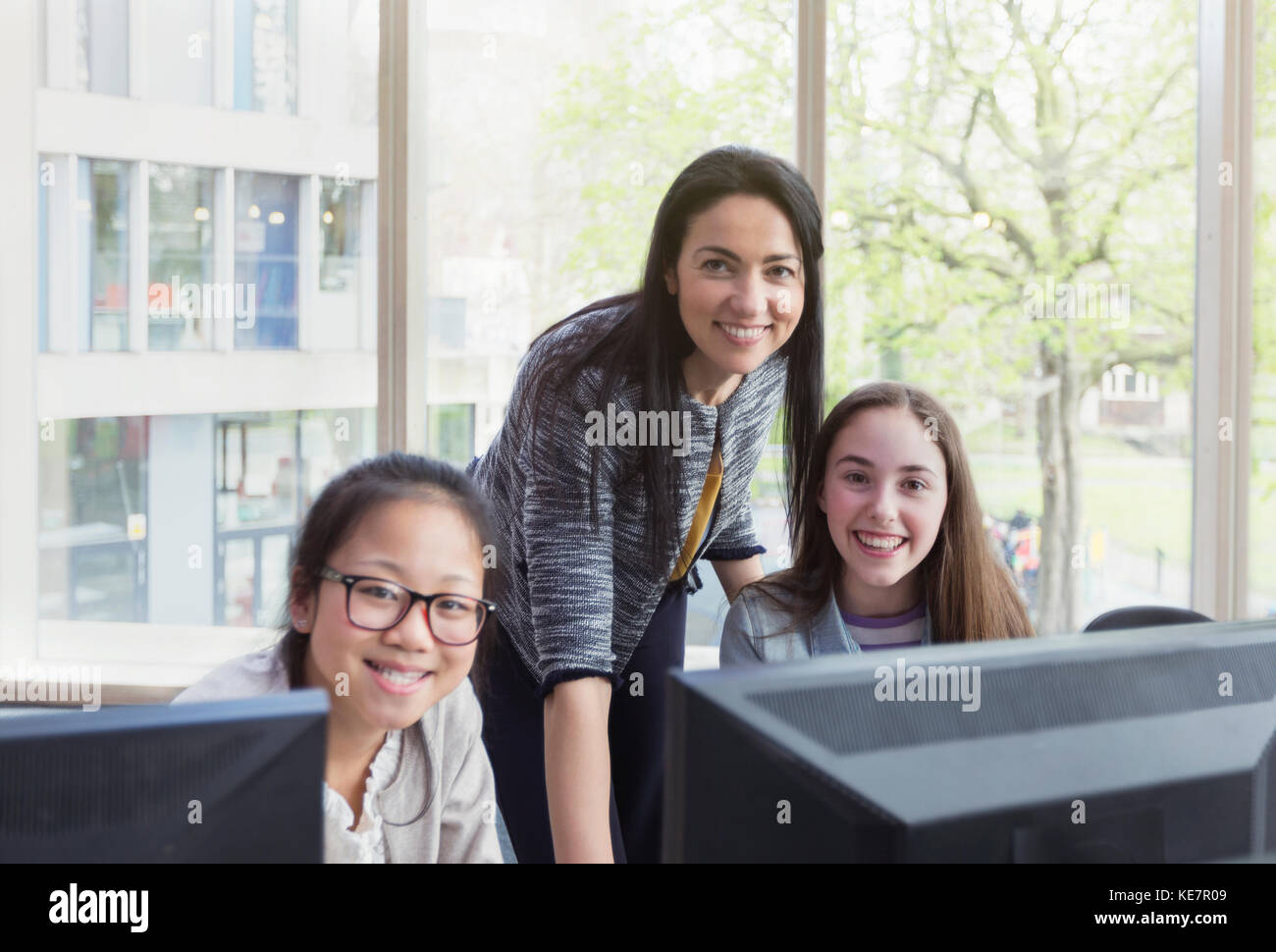 Portrait confident, smiling female teacher and girl students ... Portrait confident, smiling female teacher and girl students ...